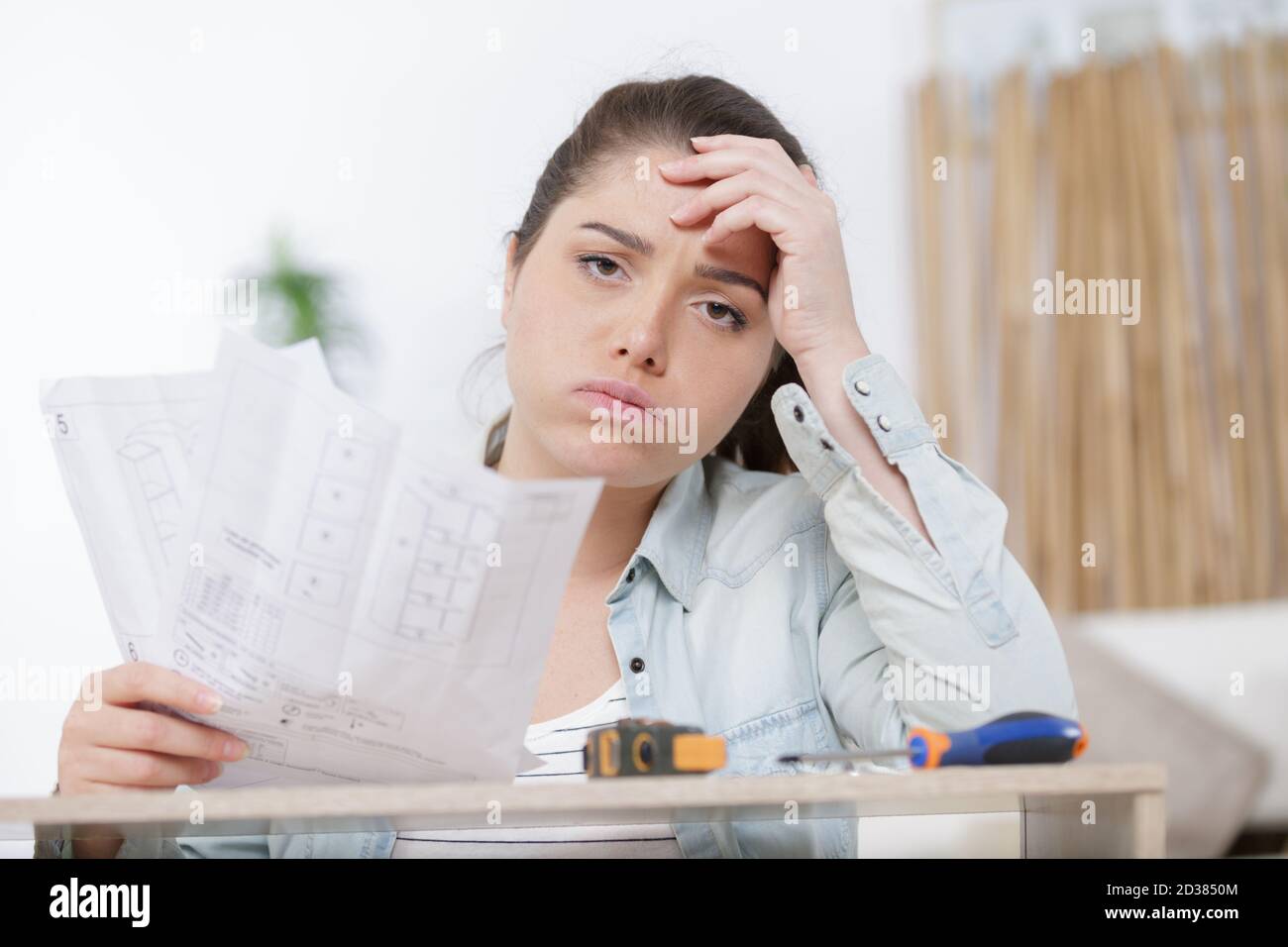 frustrated woman with self assembly furniture in kitchen Stock Photo ...