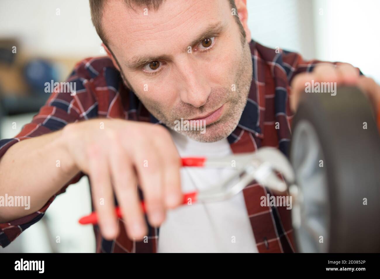 man fixing wheel with a tool Stock Photo - Alamy