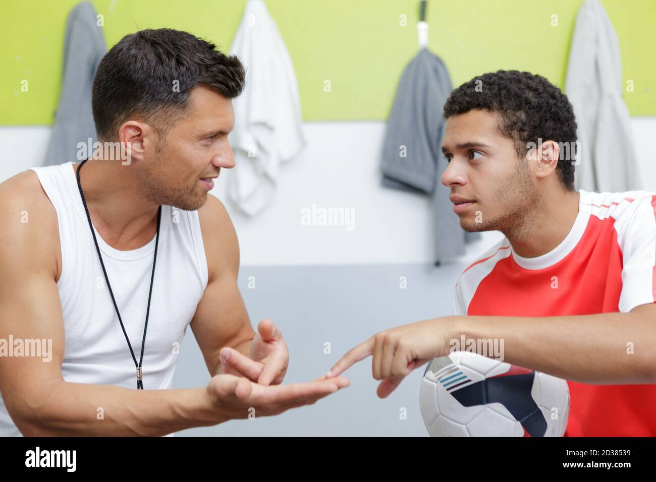 coach and player talking in changing room Stock Photo - Alamy