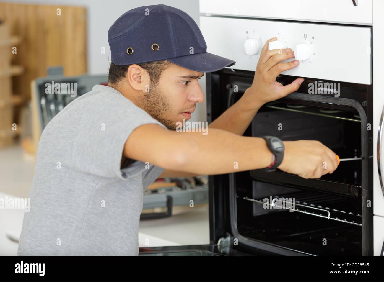 a serviceman installing new oven Stock Photo - Alamy