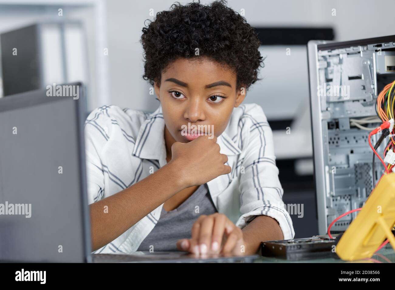 female computer technician looking at laptop Stock Photo - Alamy