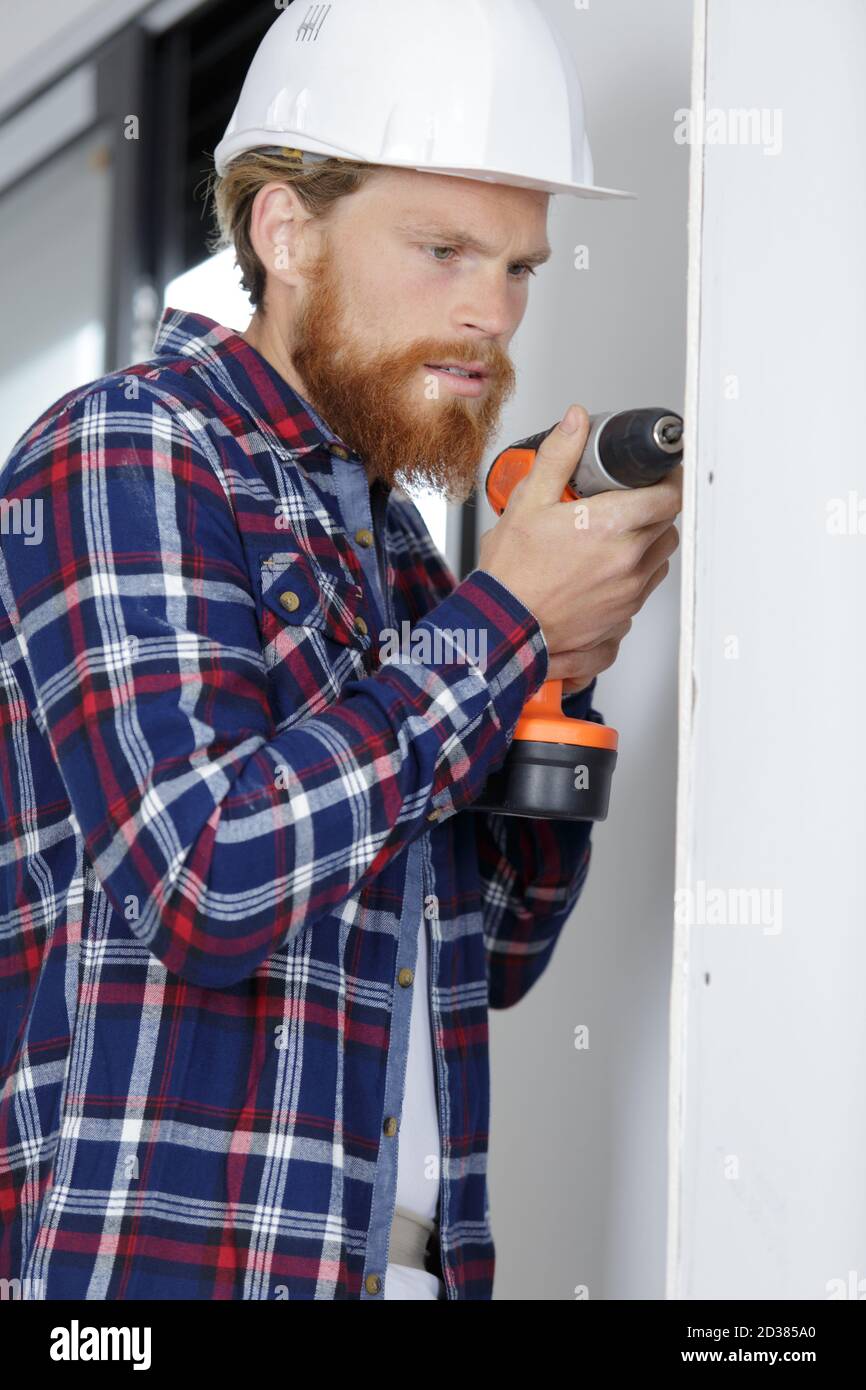man with hard hat on construction site using drill Stock Photo - Alamy
