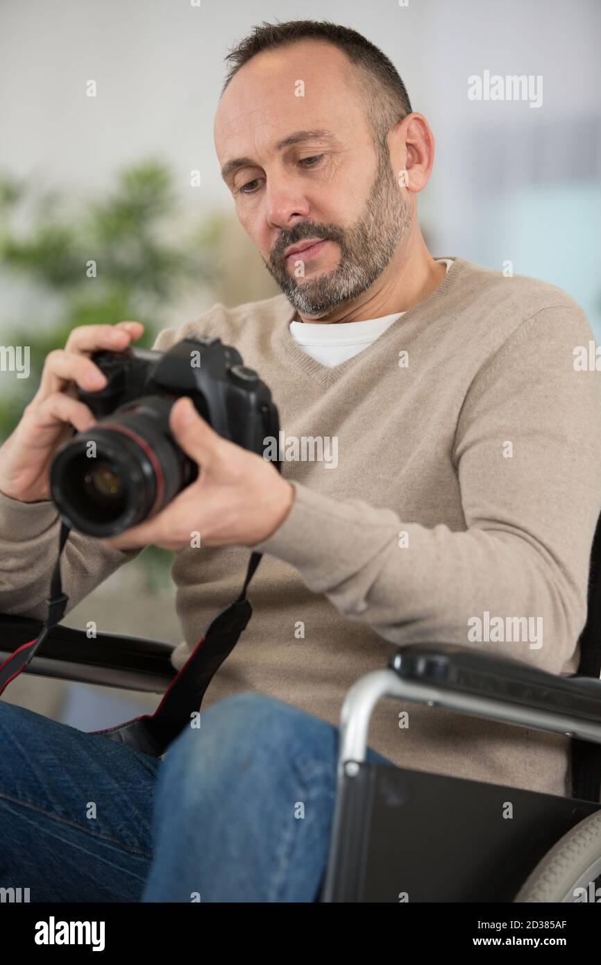 disabled man in a wheelchair using a camera Stock Photo - Alamy