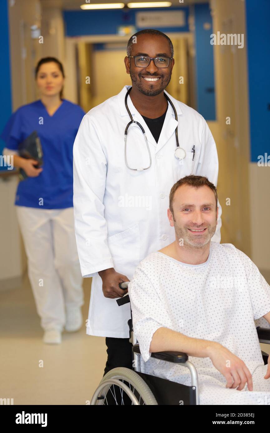 doctor pushing adult male patient in wheelchair Stock Photo - Alamy