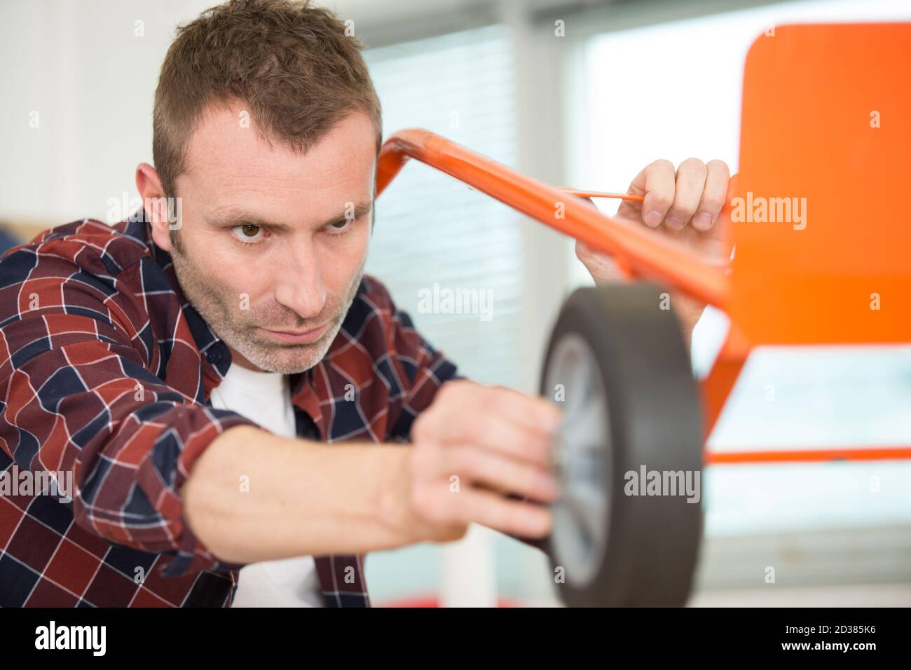 man fixing a trolley wheel Stock Photo - Alamy