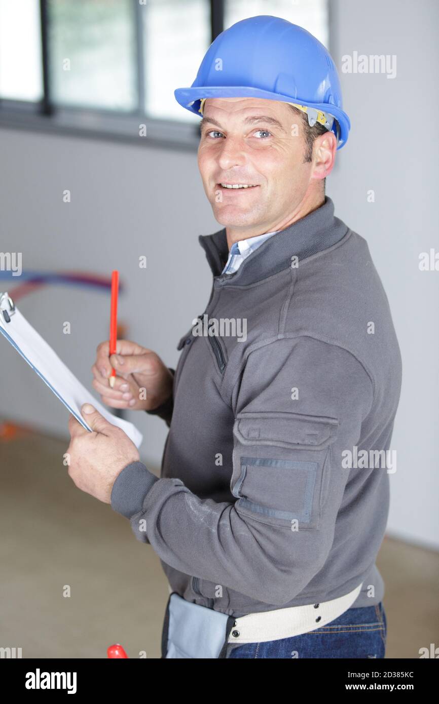 male builder in hard hat holds clipboard Stock Photo - Alamy