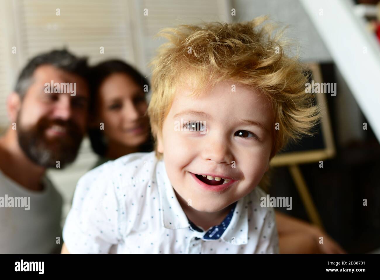 Parents and son with proud and happy faces play together. Young family ...