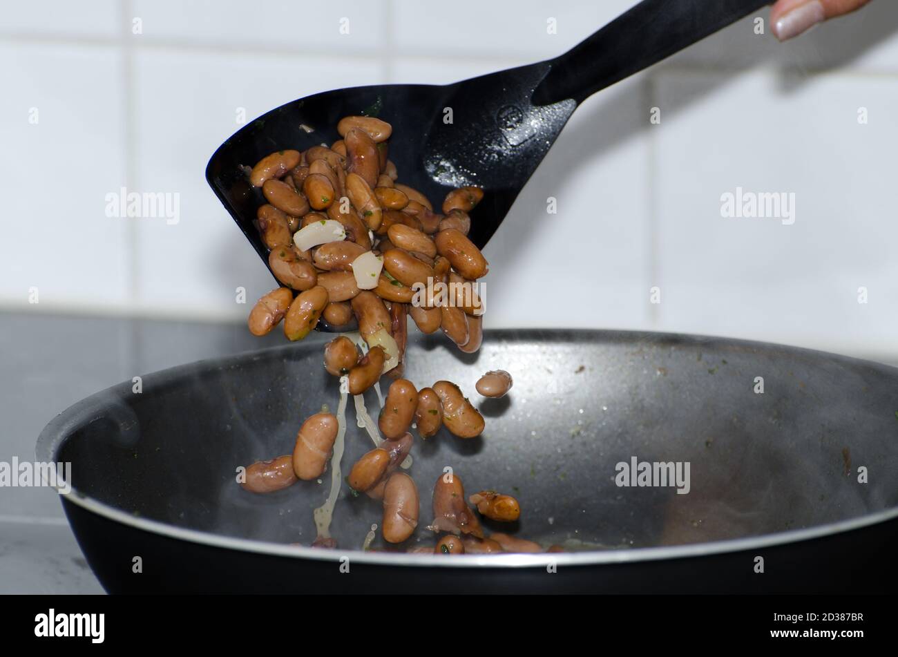 Cooking Beans with a Frying Pan Stock Photo - Alamy