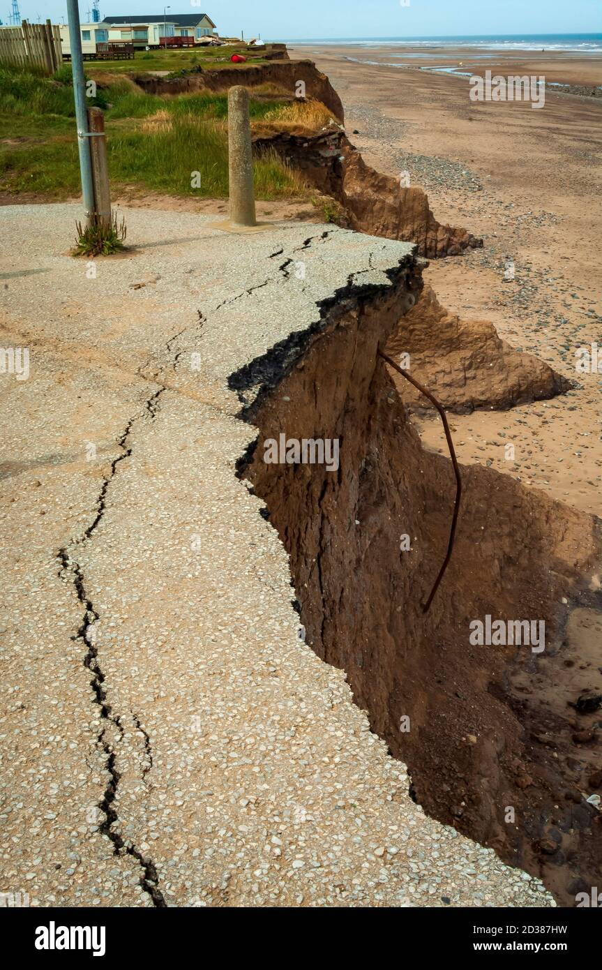 Eroded coastal road at Easington, Humberside, collapsing onto a pebble ...