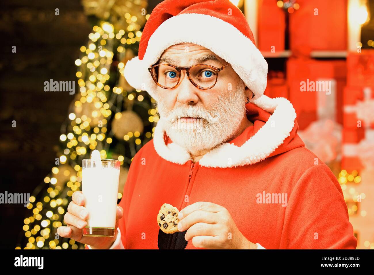 Santa make funny face and picking cookie. Santa Claus holding Christmas ...