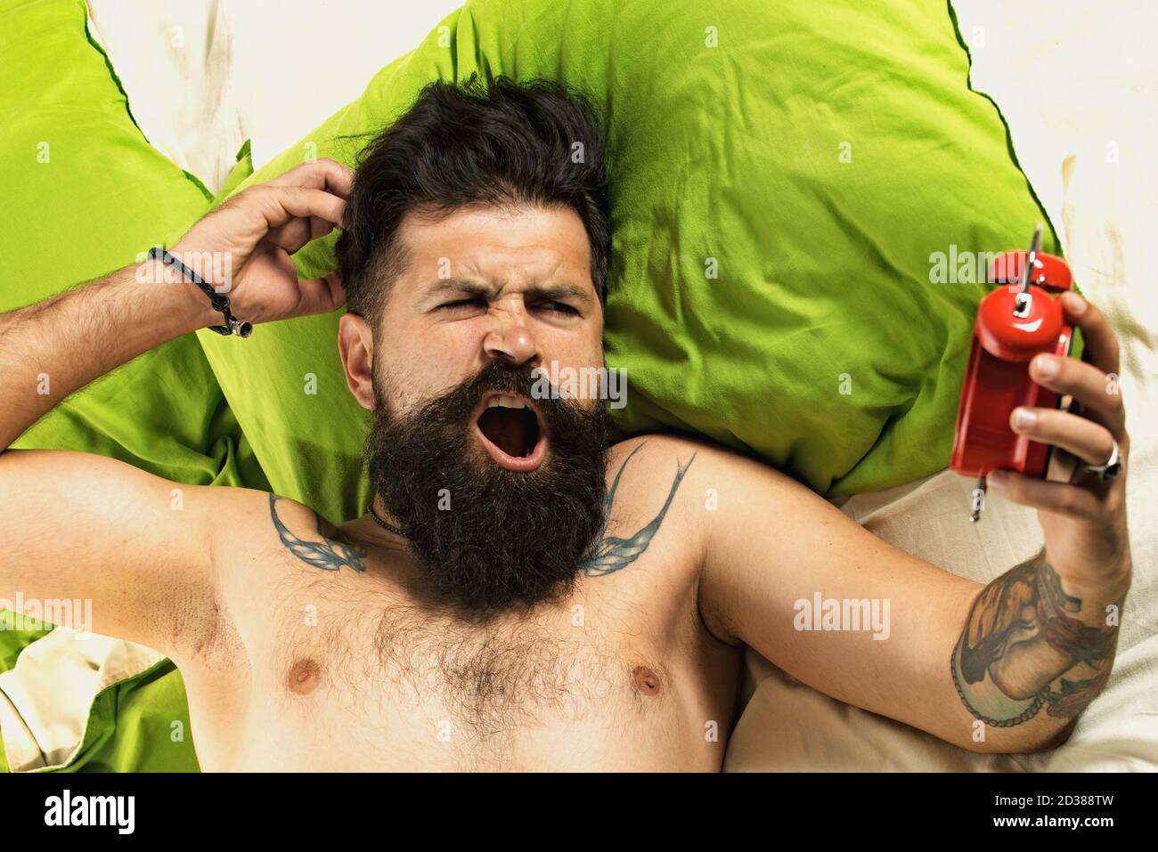 Alarm concept. Handsome man sleeps in the bedroom - lying on bed ...