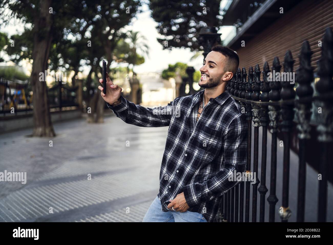 Young male with a beard wearing a black flannel shirt and video calling ...
