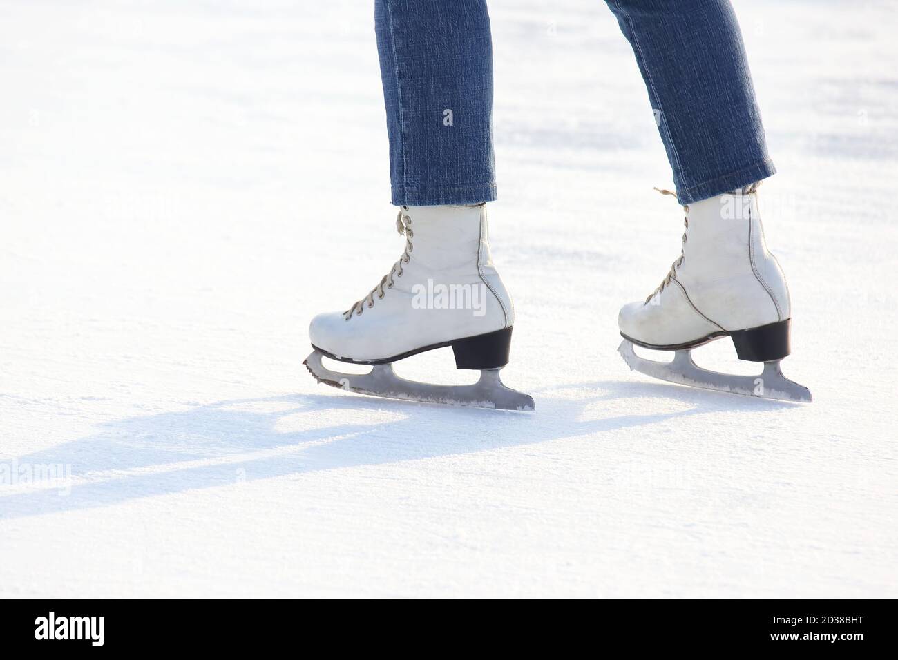 Women's feet in white ice skating on ice rink Stock Photo - Alamy