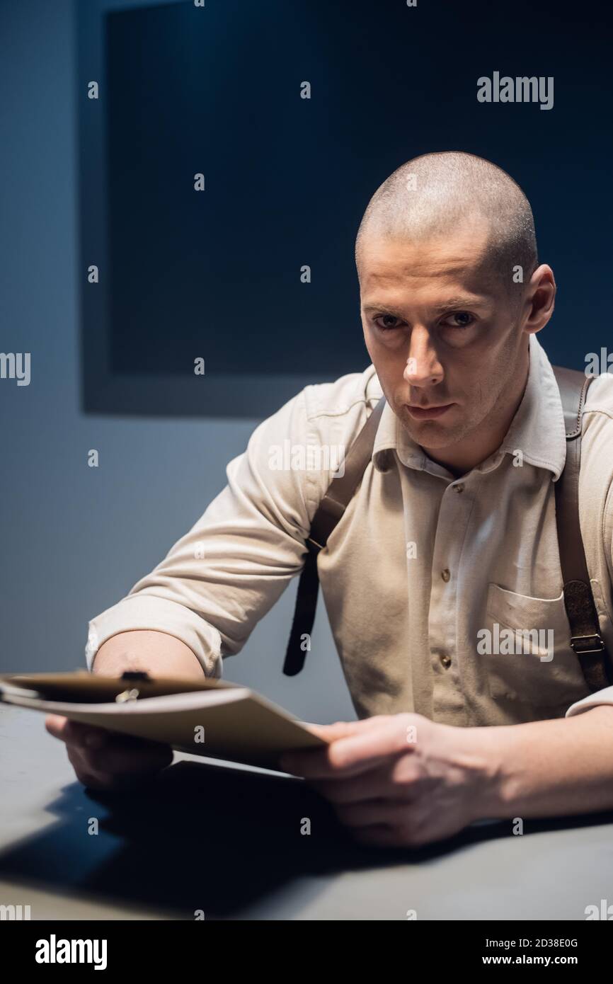 A close-up portrait of an experienced police officer sitting at a desk ...