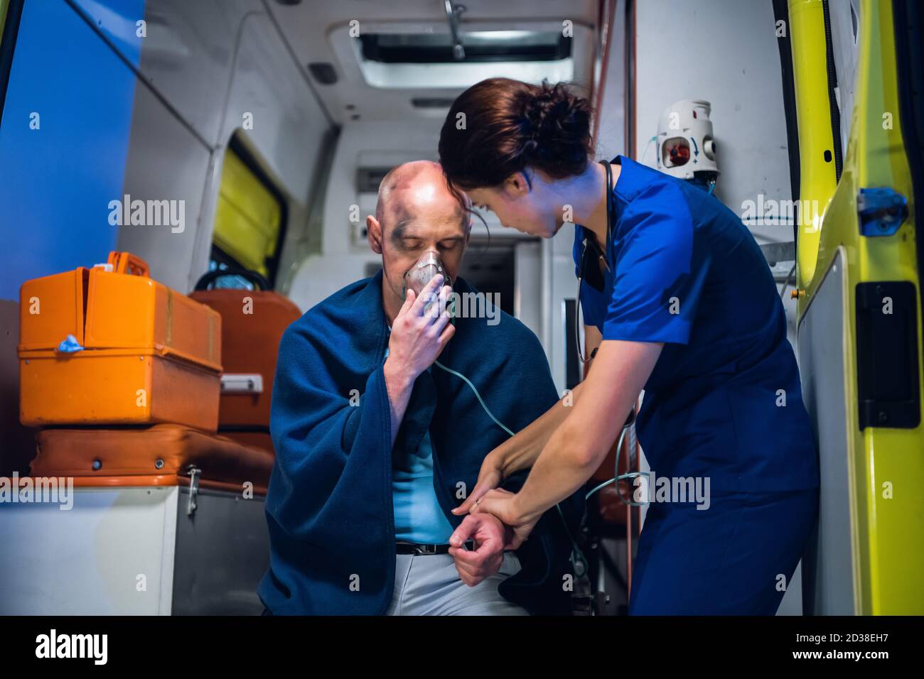 A female paramedic providing first aid to an injured man resqued from ...