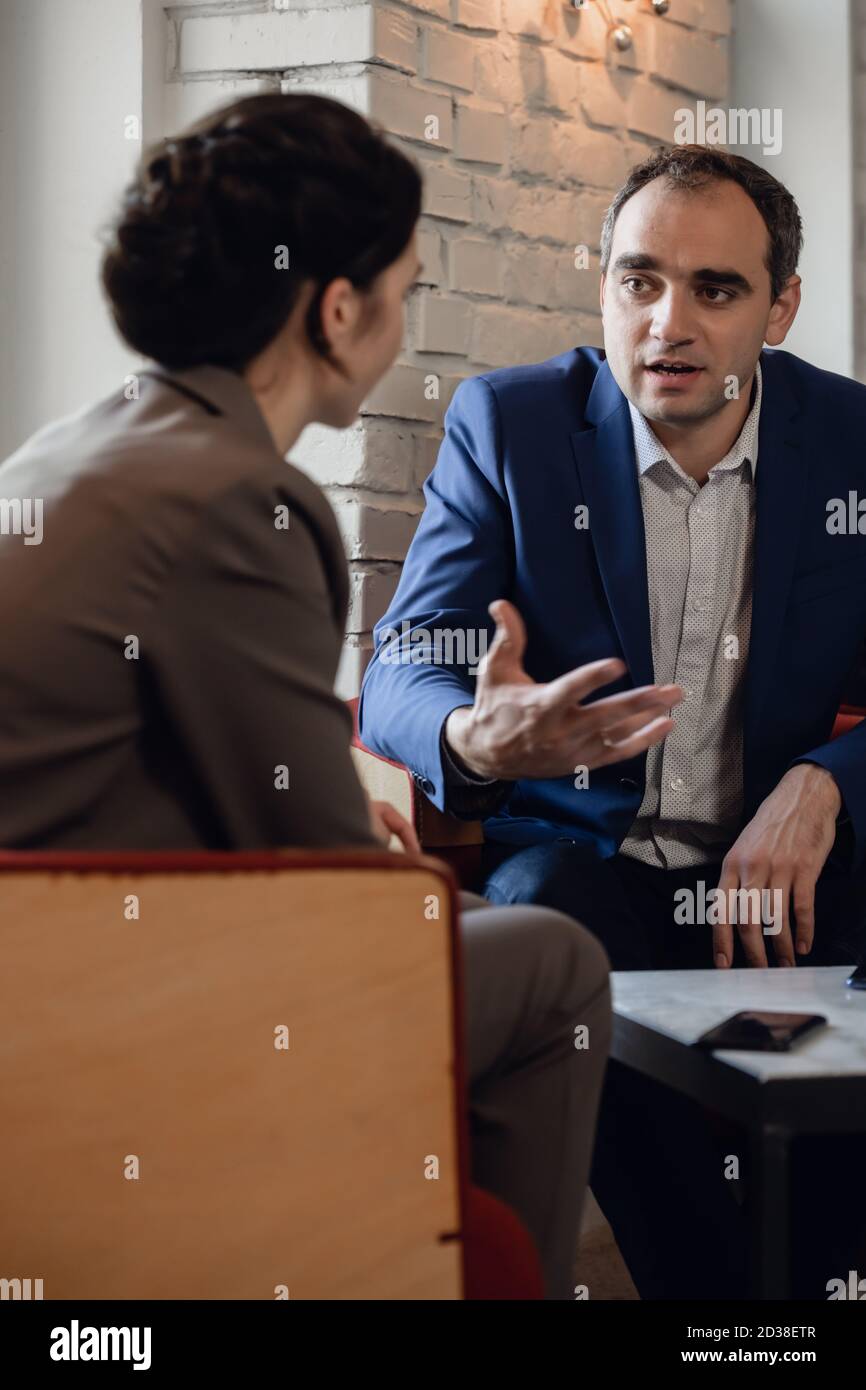 Two people discussing bussiness questions in an informal setting. The ...