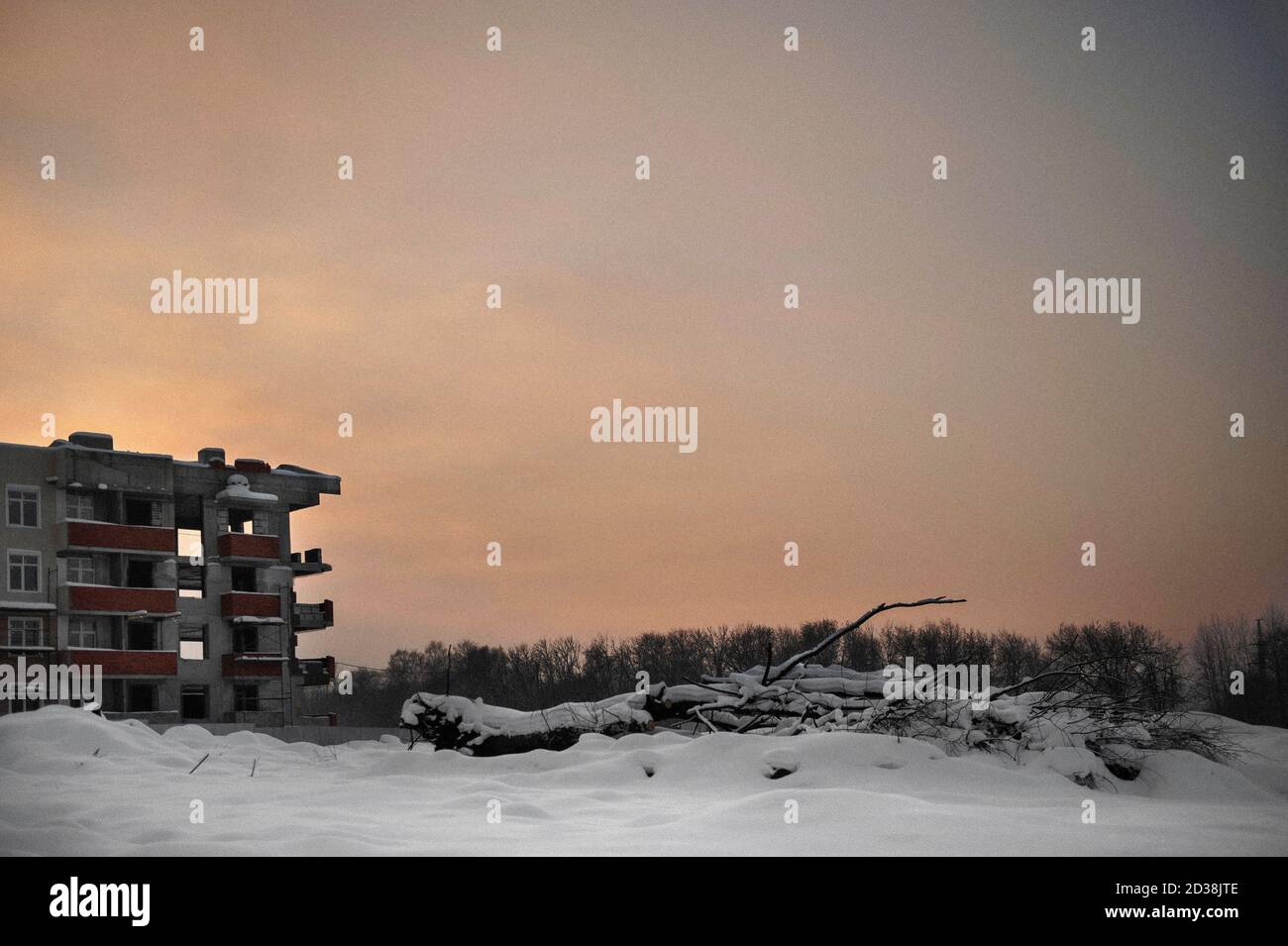 A ruined concrete building in a snow-covered landscape underneath a ...