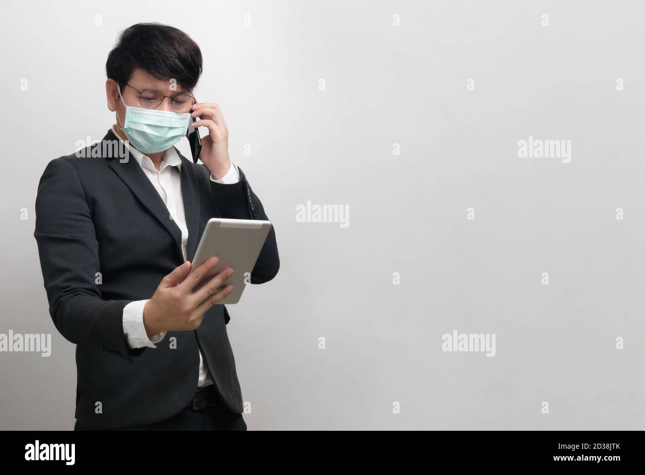 Asian businessman wearing surgical face mask in formal black suit ...