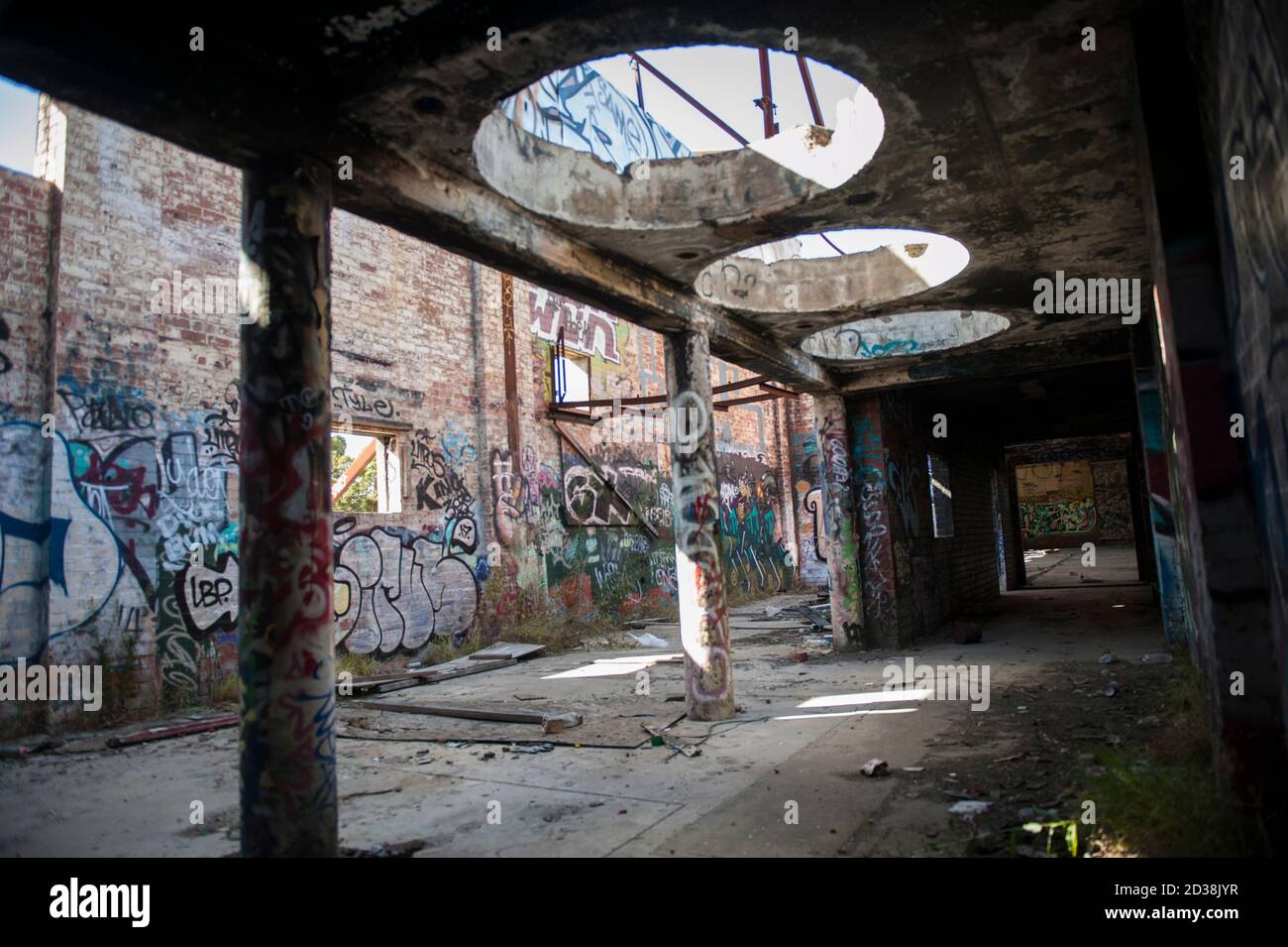 Derelict structures covered in graffiti at the abandoned Bradmill Cotton Mill factory at ...