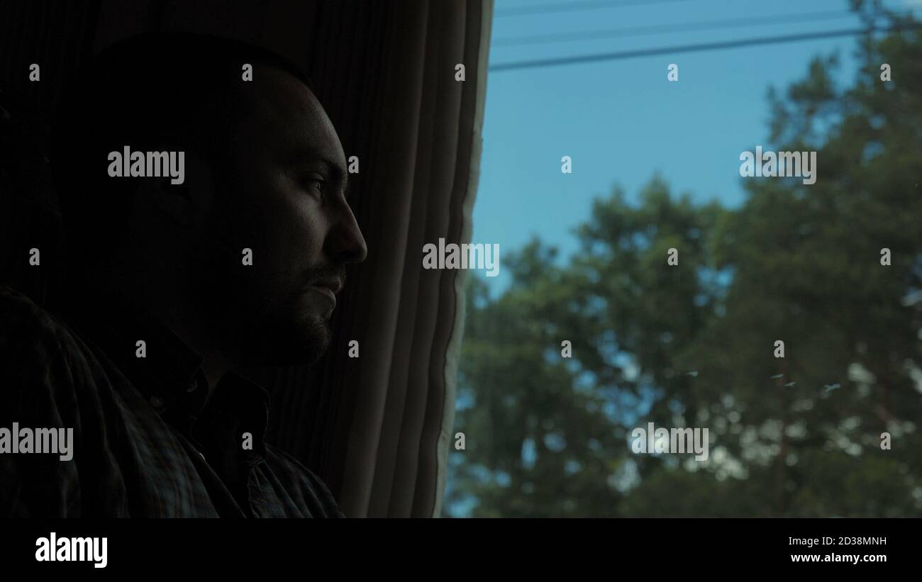 Sad young man looking through the window of the train Stock Photo - Alamy