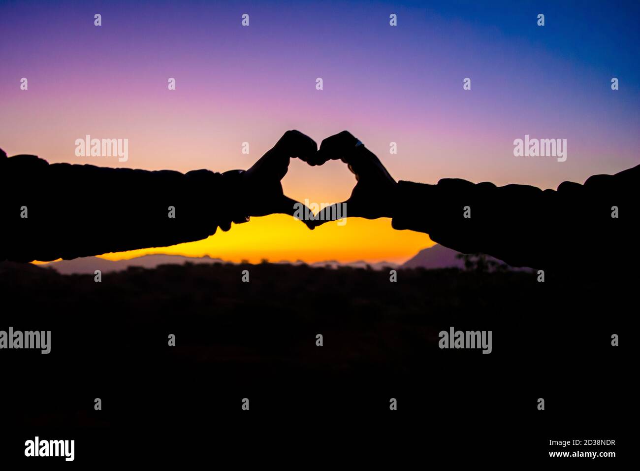 heart shape by hands in silhouette while watching the sunset Stock ...