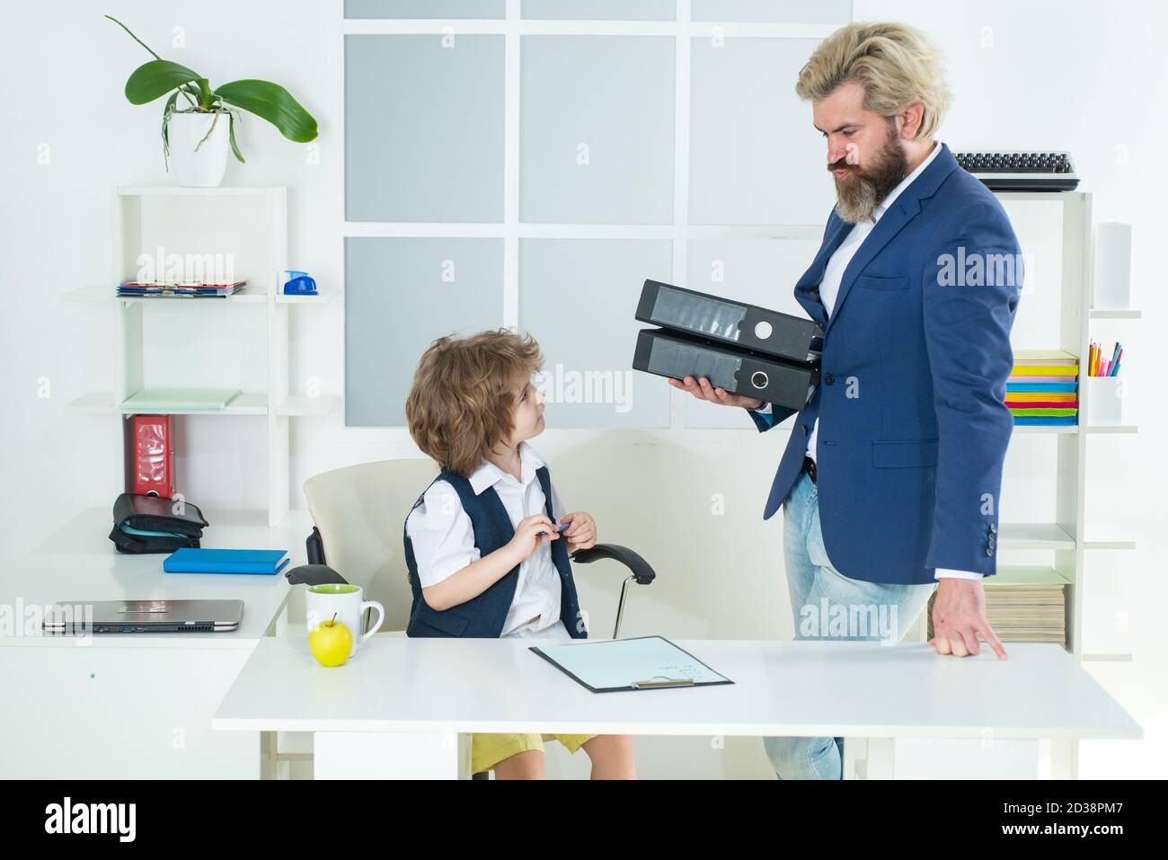Little kid playing to be boss on a business desk in office. Business ...