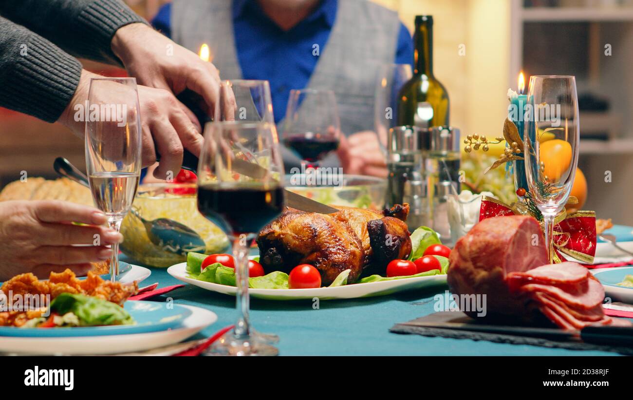 Close up of father slicing the chicken for his family at christmas ...
