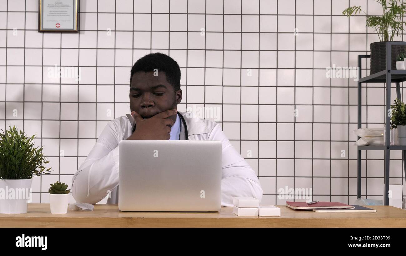 African American doctor working at computer and laptop reading s Stock ...