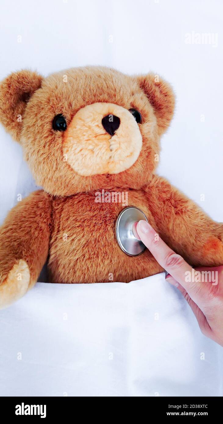 sick cuddly toy with a stethoscope in a bed Stock Photo - Alamy