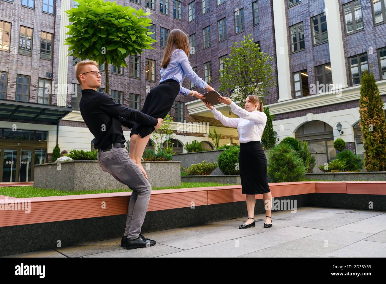 Three members in balance asana of acro yoga with base partner, flyer ...