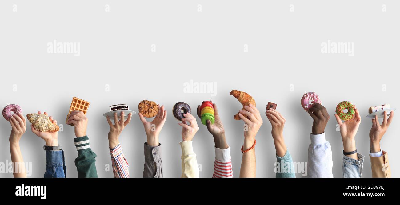 People are holding different desserts in their hands. The concept of ...
