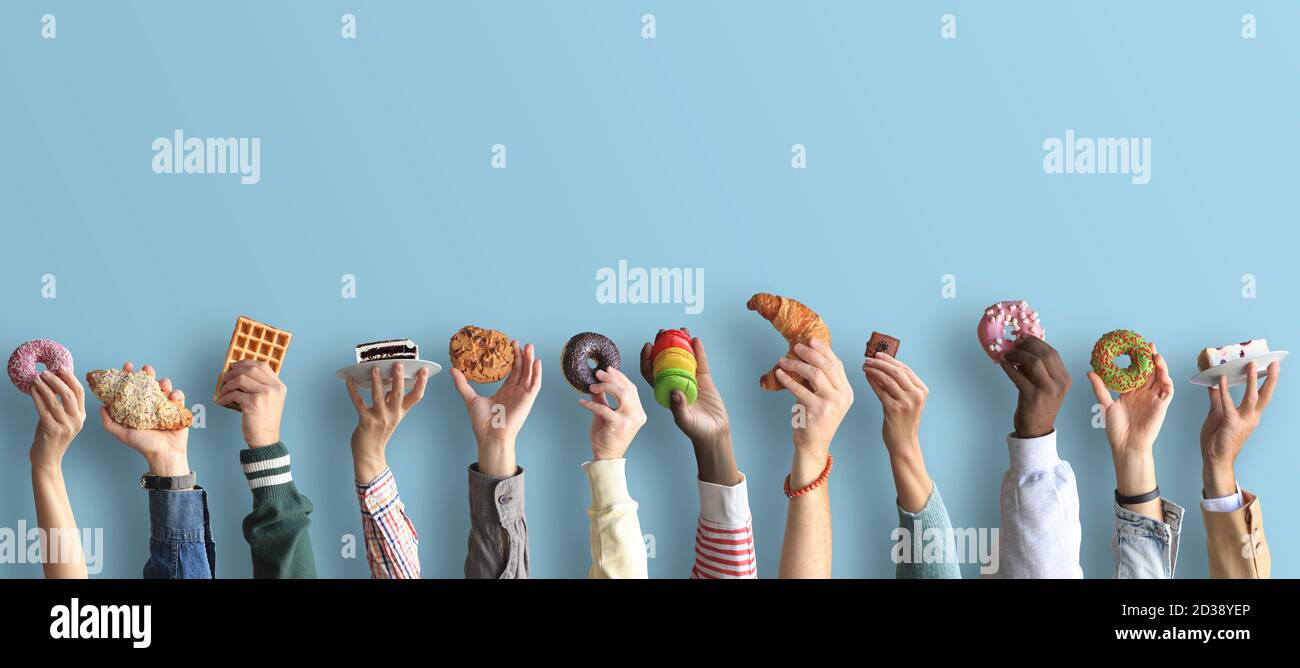 People are holding different desserts in their hands. The concept of ...