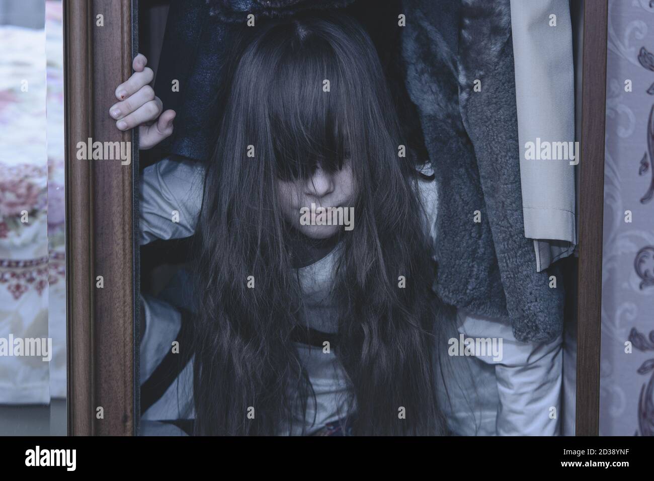 Mad scary girl in cupboard at dark night. Horror background with child ...