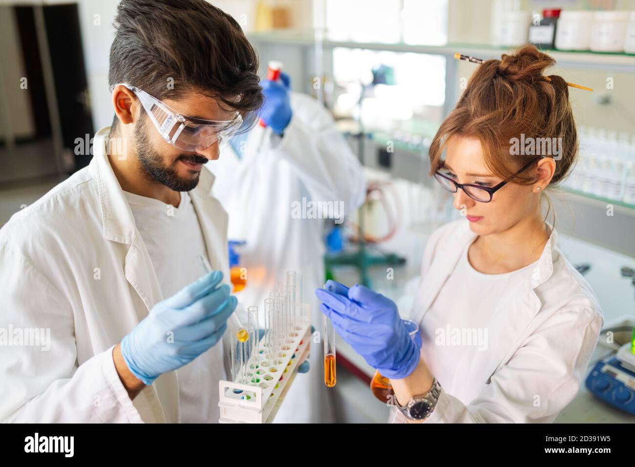 Group of medical research scientists collectively working in laboratory ...