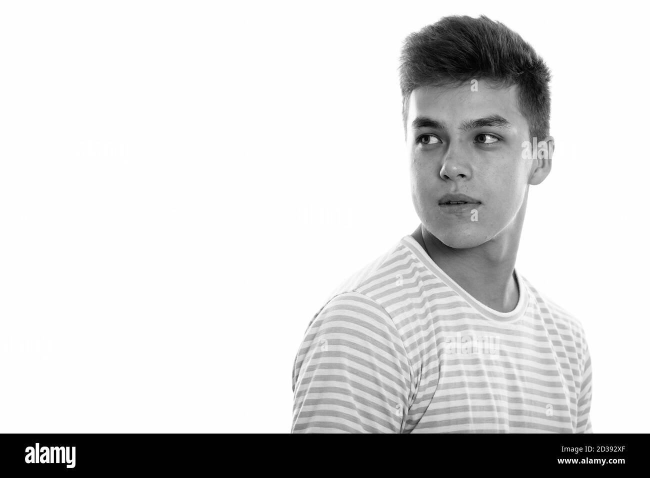 Studio shot of young handsome man thinking while looking back Stock ...