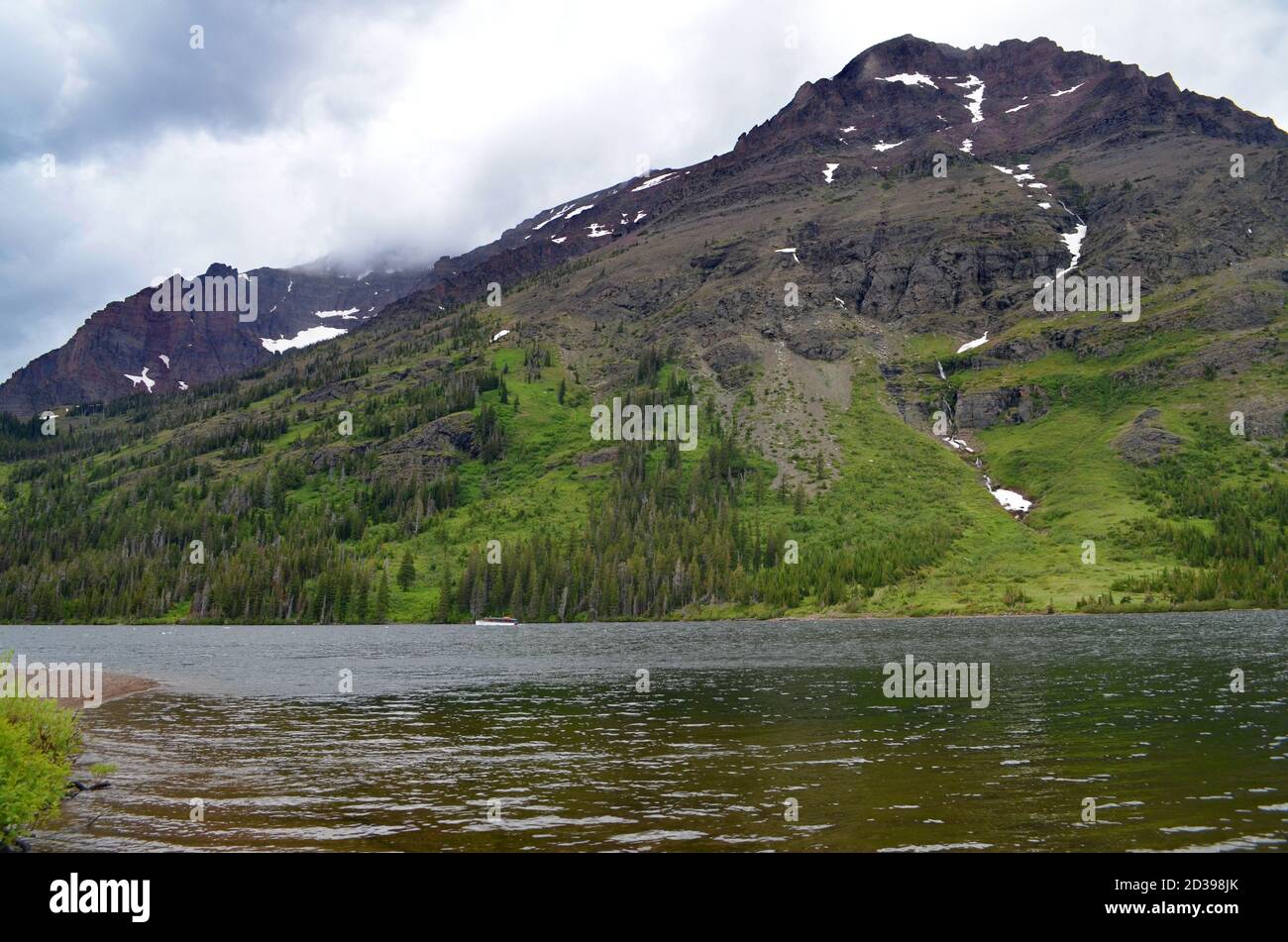 Montana - Mountain looming over Boat on Two Medicine Lake Stock Photo ...