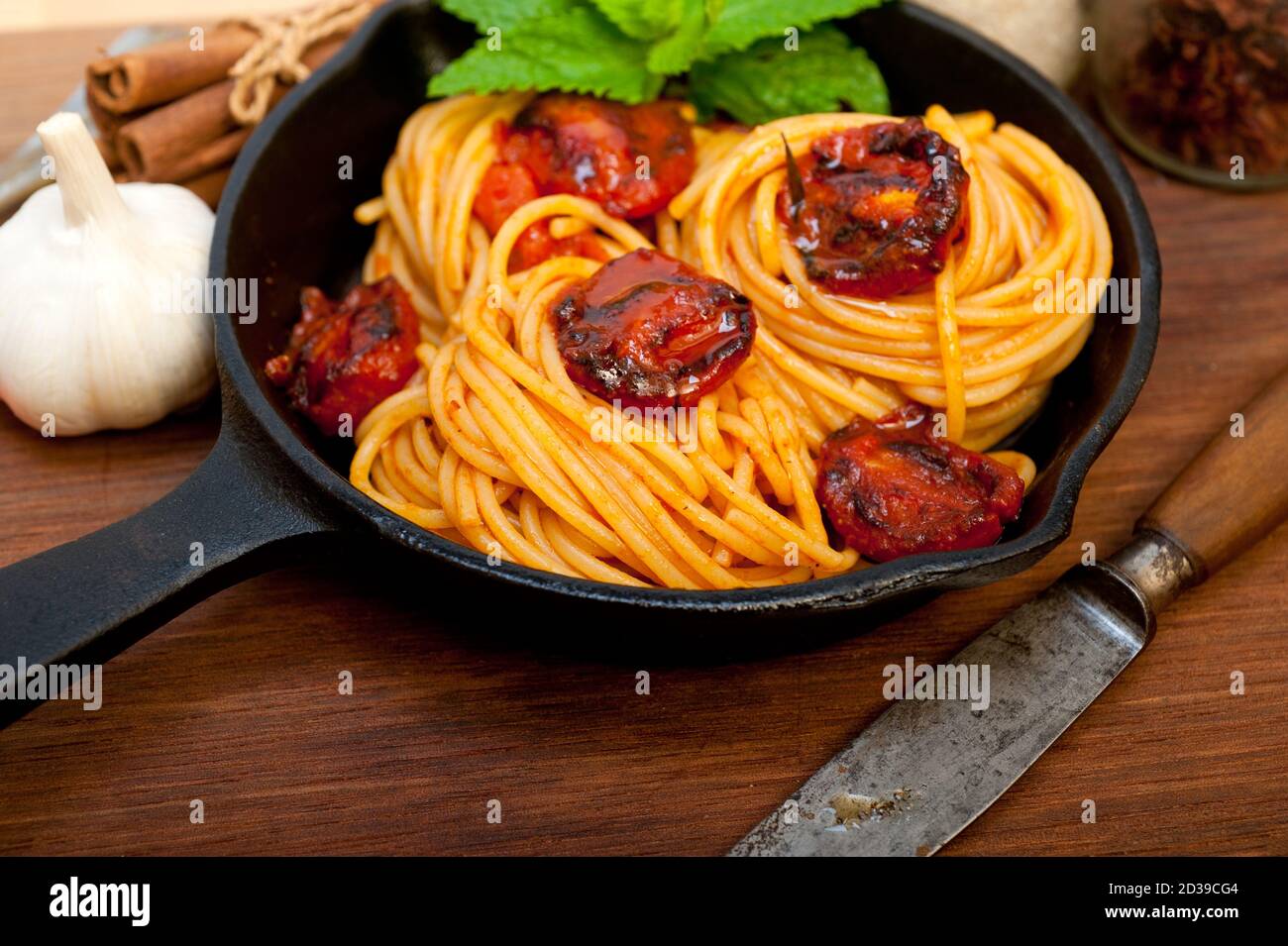 italian spaghetti pasta and tomato with mint leaves on iron skillet ...