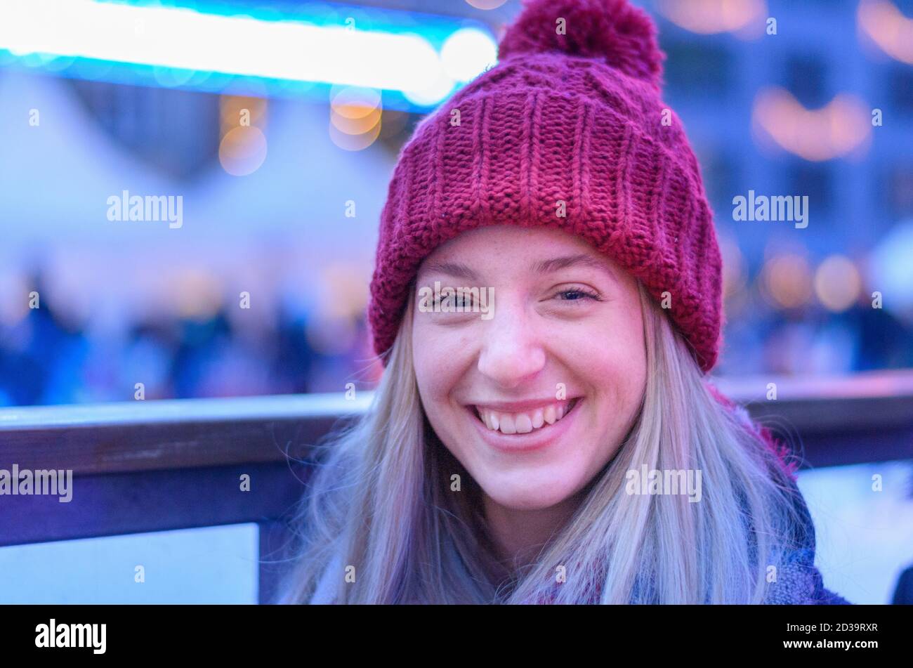 Close up of a happy vivacious woman at a night fairground standing ...