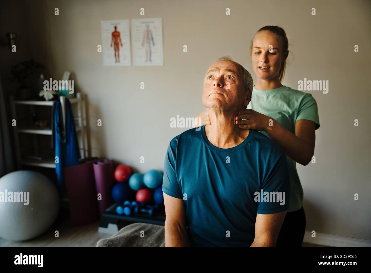 female physiotherapist performs neck test for elderly male Stock Photo ...