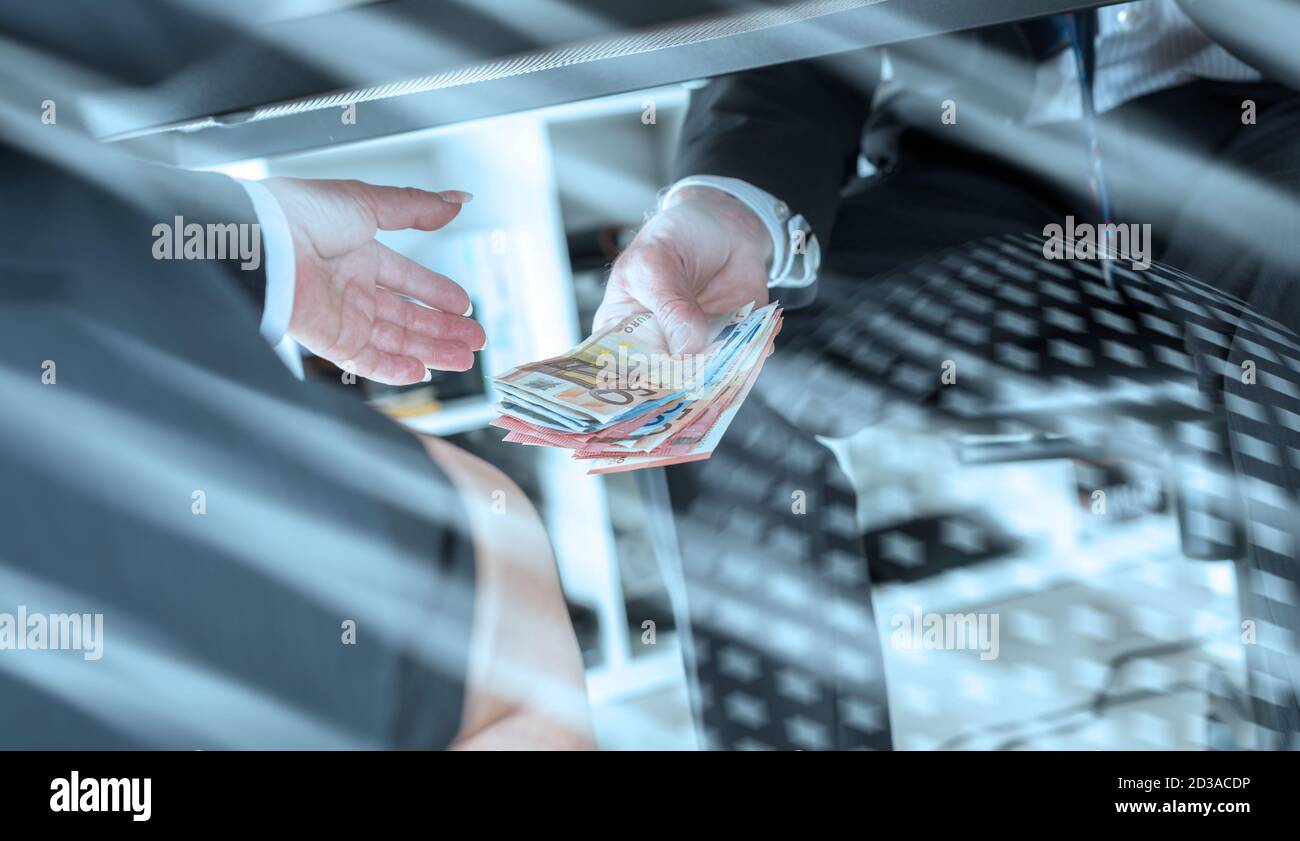 Businessman giving money under a table; light effect Stock Photo - Alamy