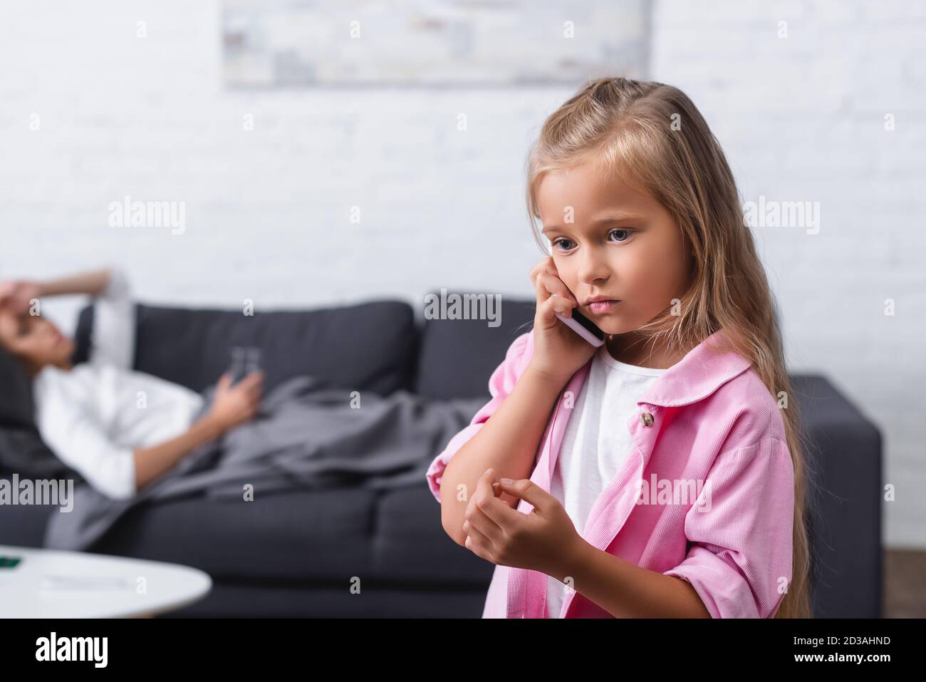 Selective focus of sad child talking on smartphone near sick mother at ...