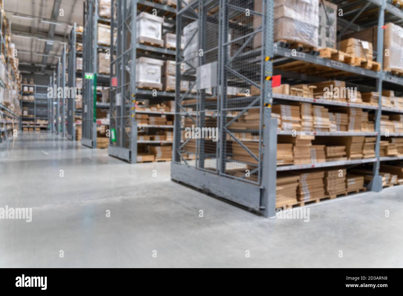 blurred background image of Rows of shelves with goods boxes in modern ...