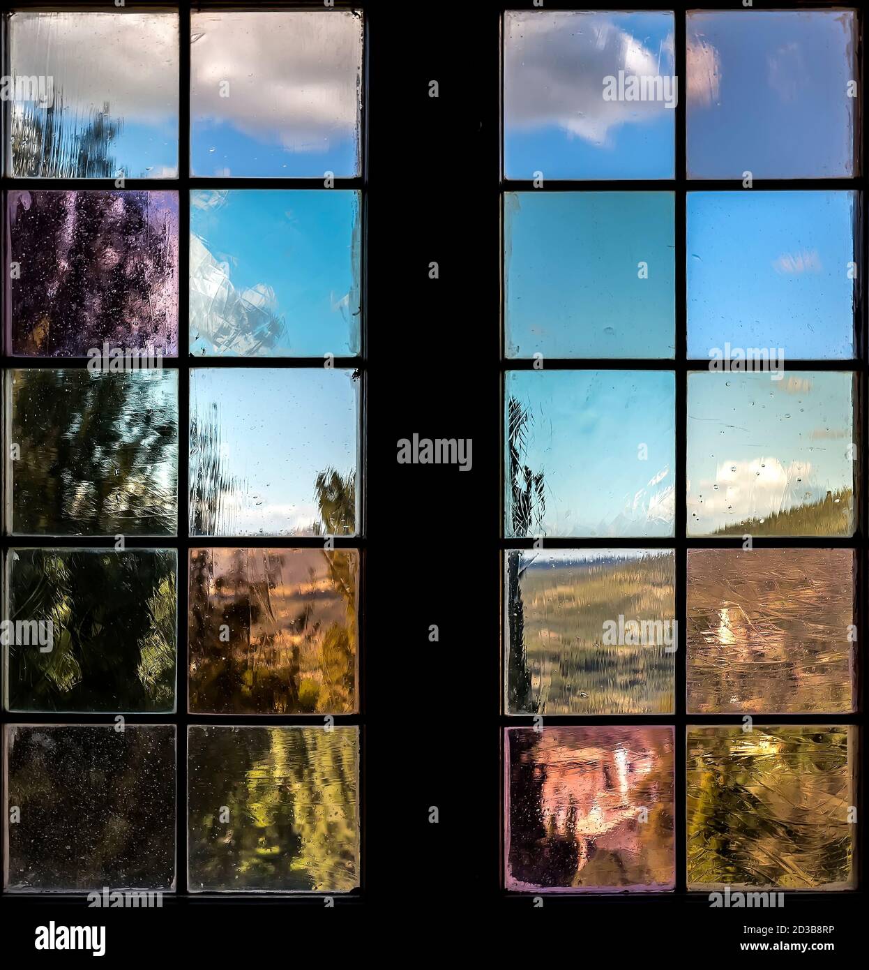 A window with multi-colored glass that overlooks a park or garden Stock ...