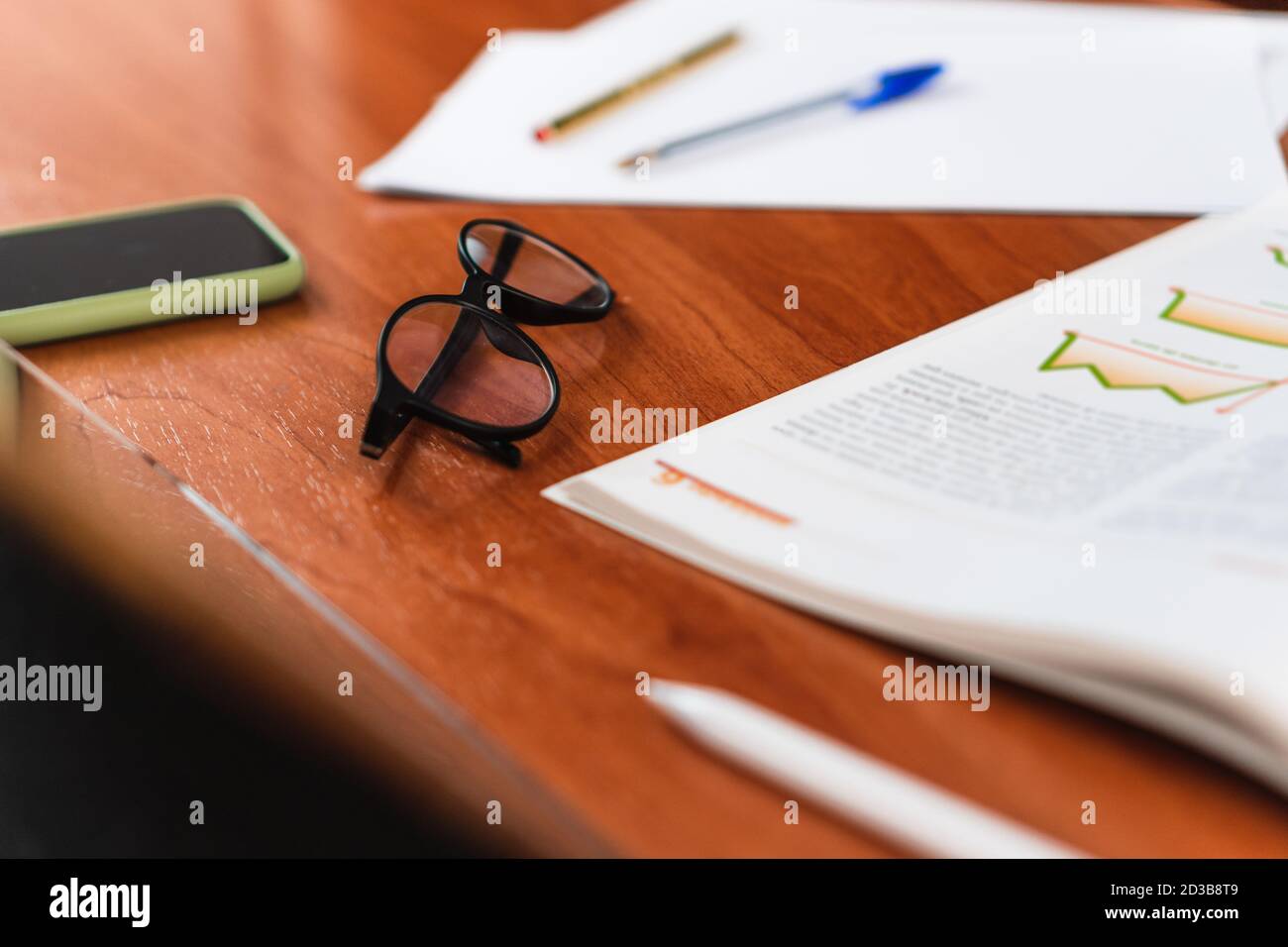 Wooden table with glasses and books Stock Photo - Alamy