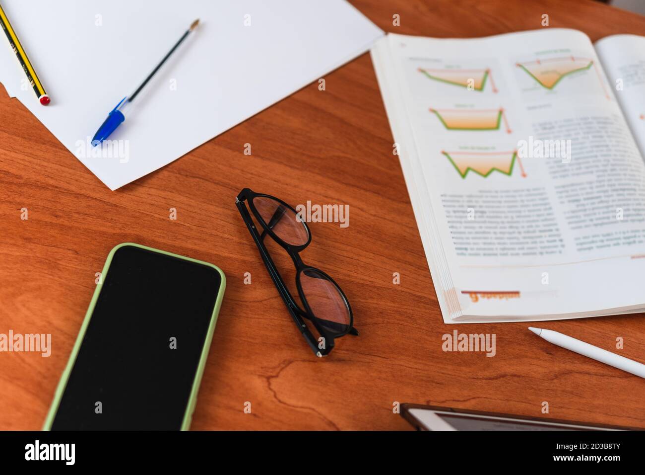 Wooden table with glasses and books Stock Photo - Alamy