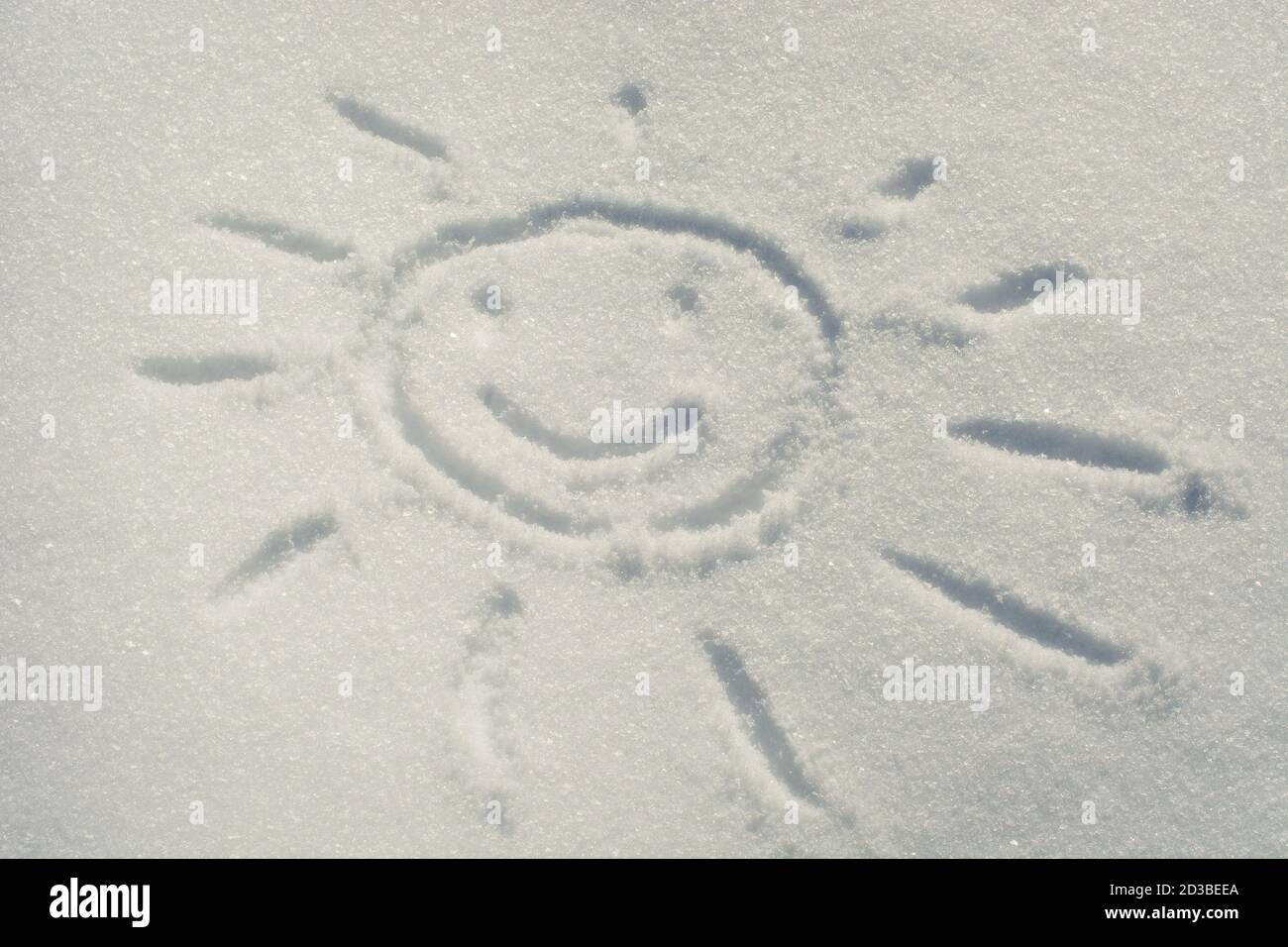 Drawing on the snow (Sun). Smiling smile Stock Photo - Alamy