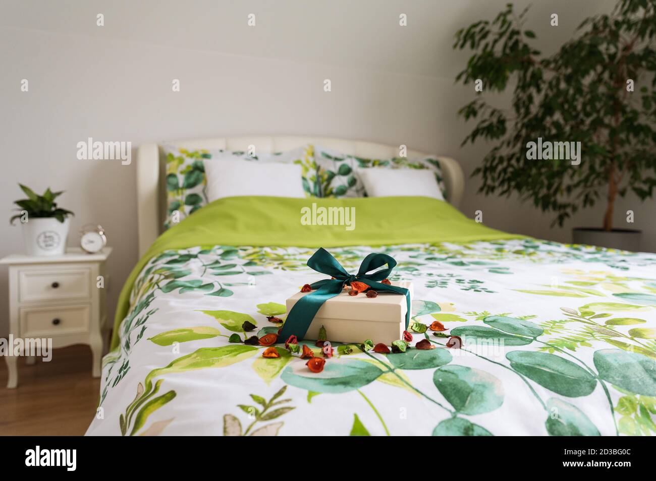 Gift in the box on a bed in the bedroom Stock Photo - Alamy