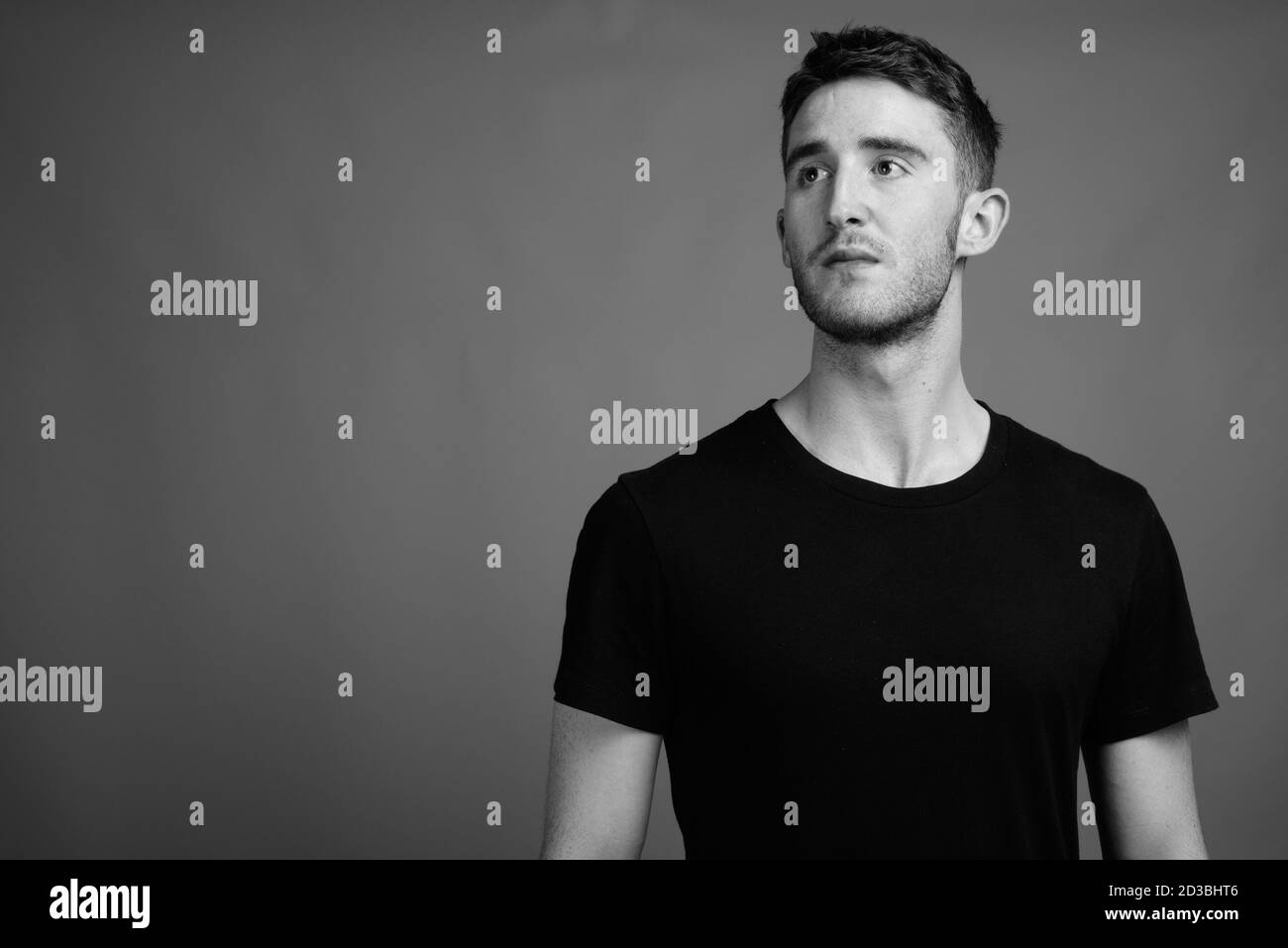 Portrait of young handsome man against gray background Stock Photo - Alamy