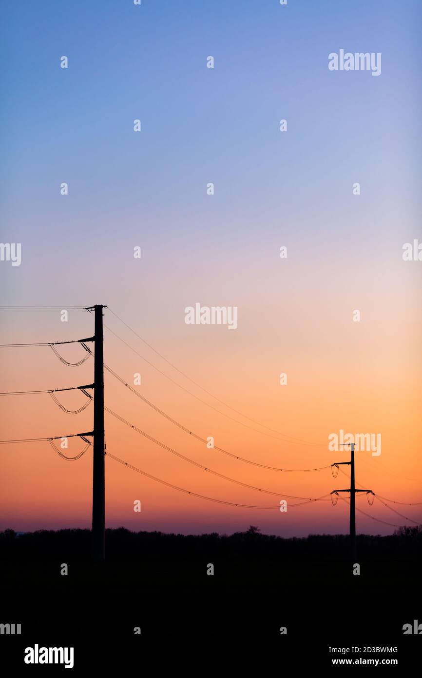Silhouette of power lines over colorful clear sky at sunrise or sunset ...