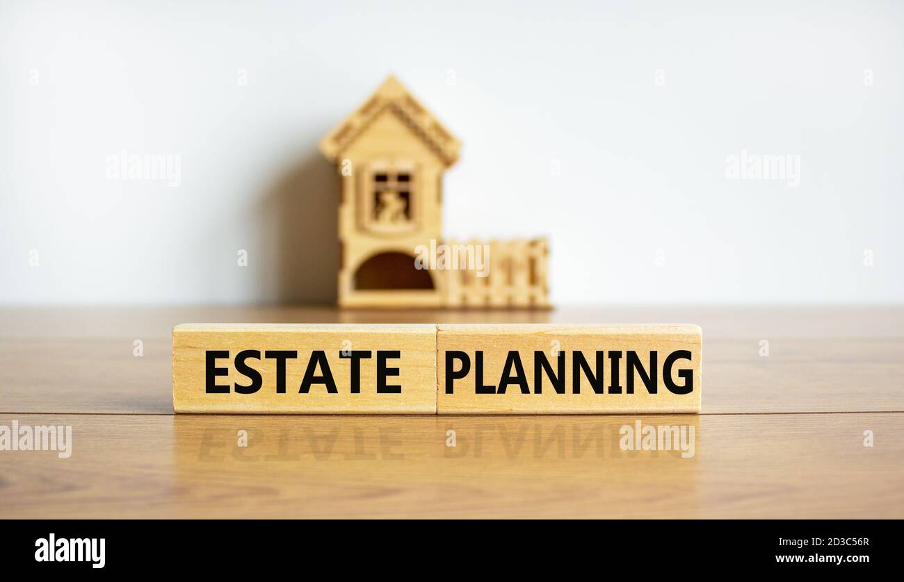 Blocks form the words estate planning in front of a miniature house ...